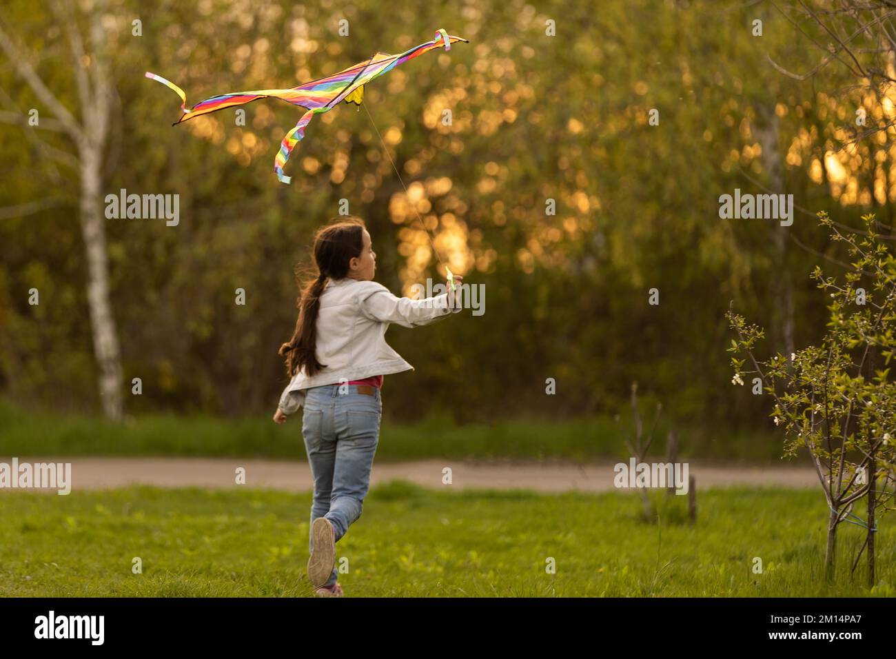 happy child girl with a kite running on meadow in nature Stock Photo ...