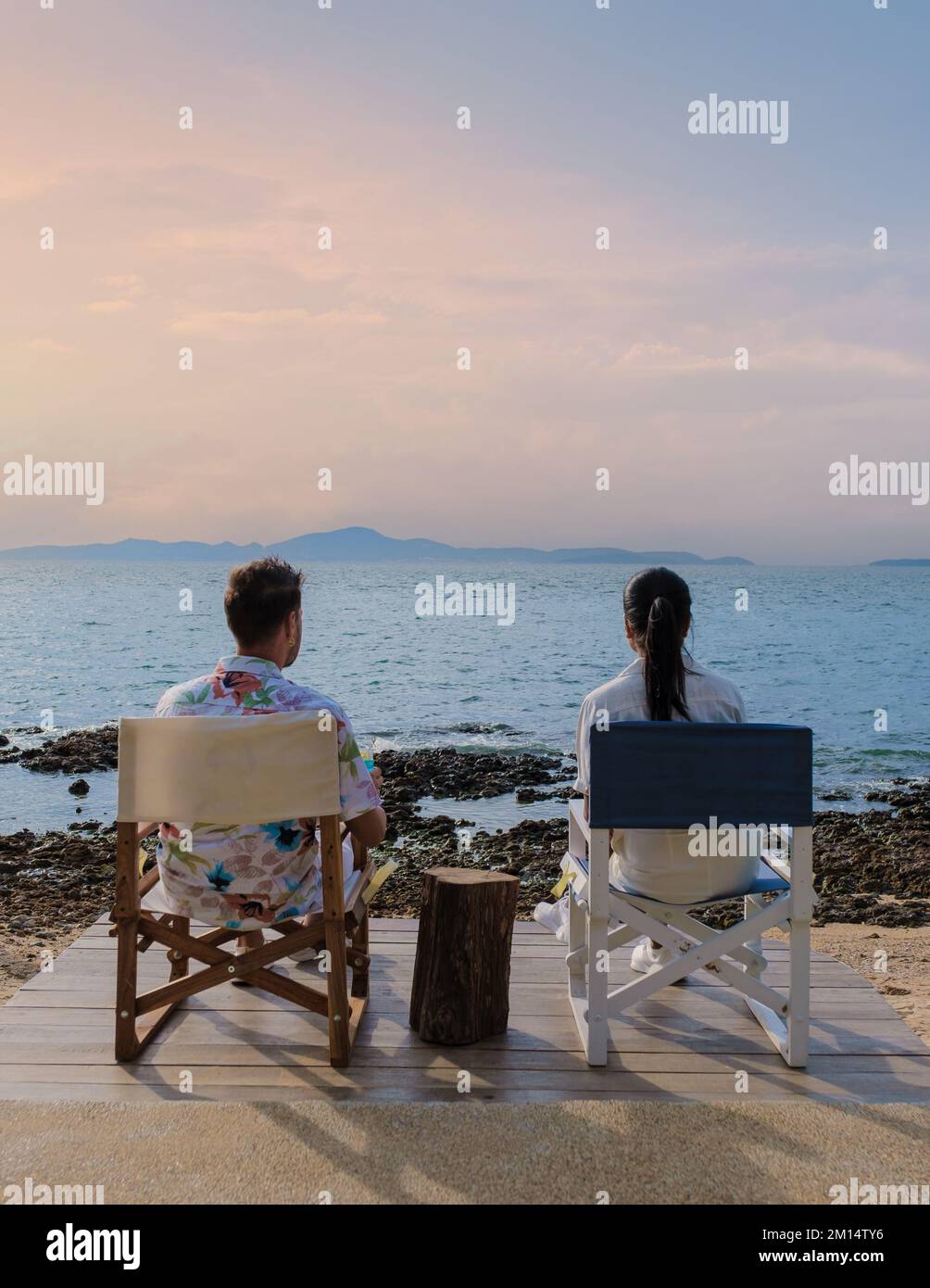 couple having lunch at a restaurant looking out over the ocean of ...