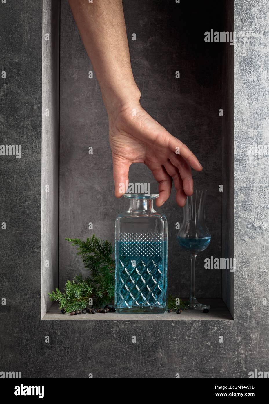 Hand reach for a decanter of gin. A concept image on the theme of ...