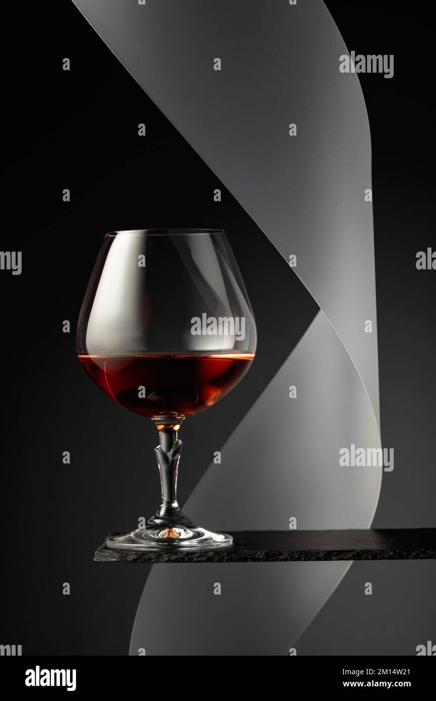 Snifter of brandy on a black background Stock Photo - Alamy
