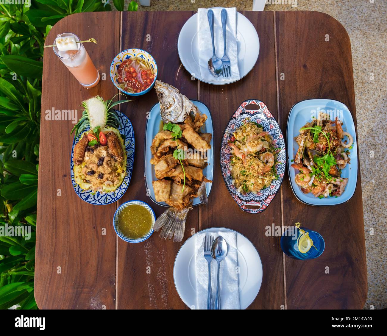 Dinner table with Thai food and bbq fish on the beach of Pattaya ...
