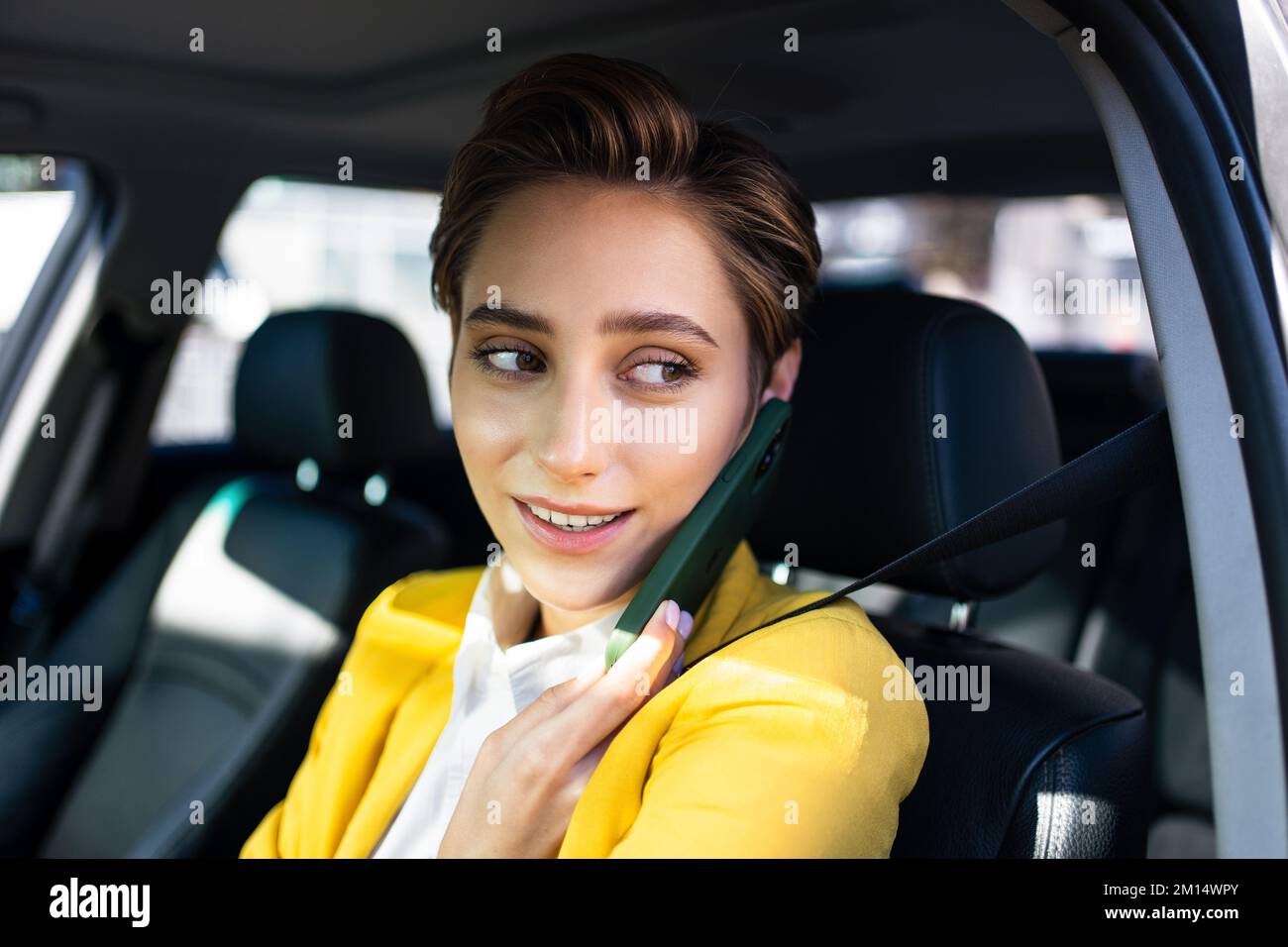 Beautiful young woman with short hair driving car in the city - Pretty ...
