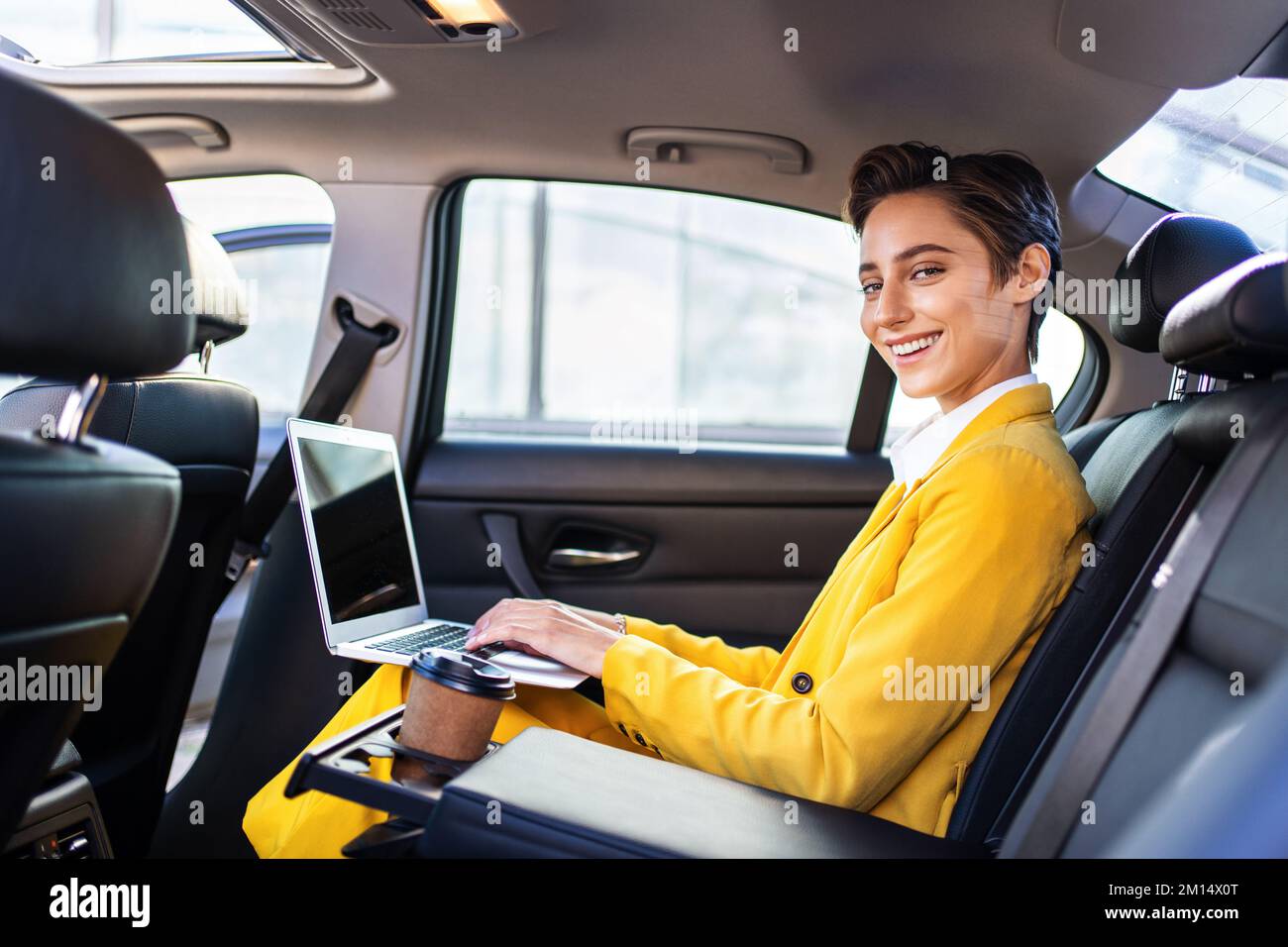 Beautiful young woman with short hair driving car in the city - Pretty ...
