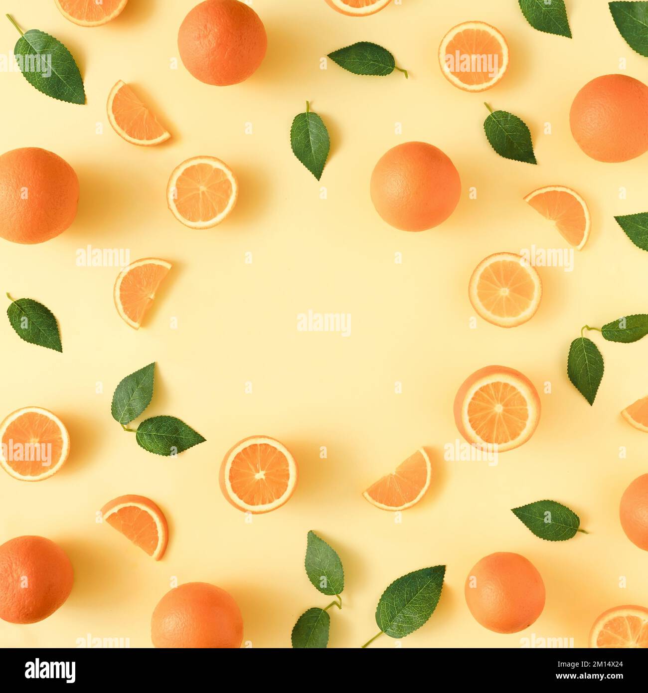 A pattern of oranges and green leaves on a yellow background with a ...