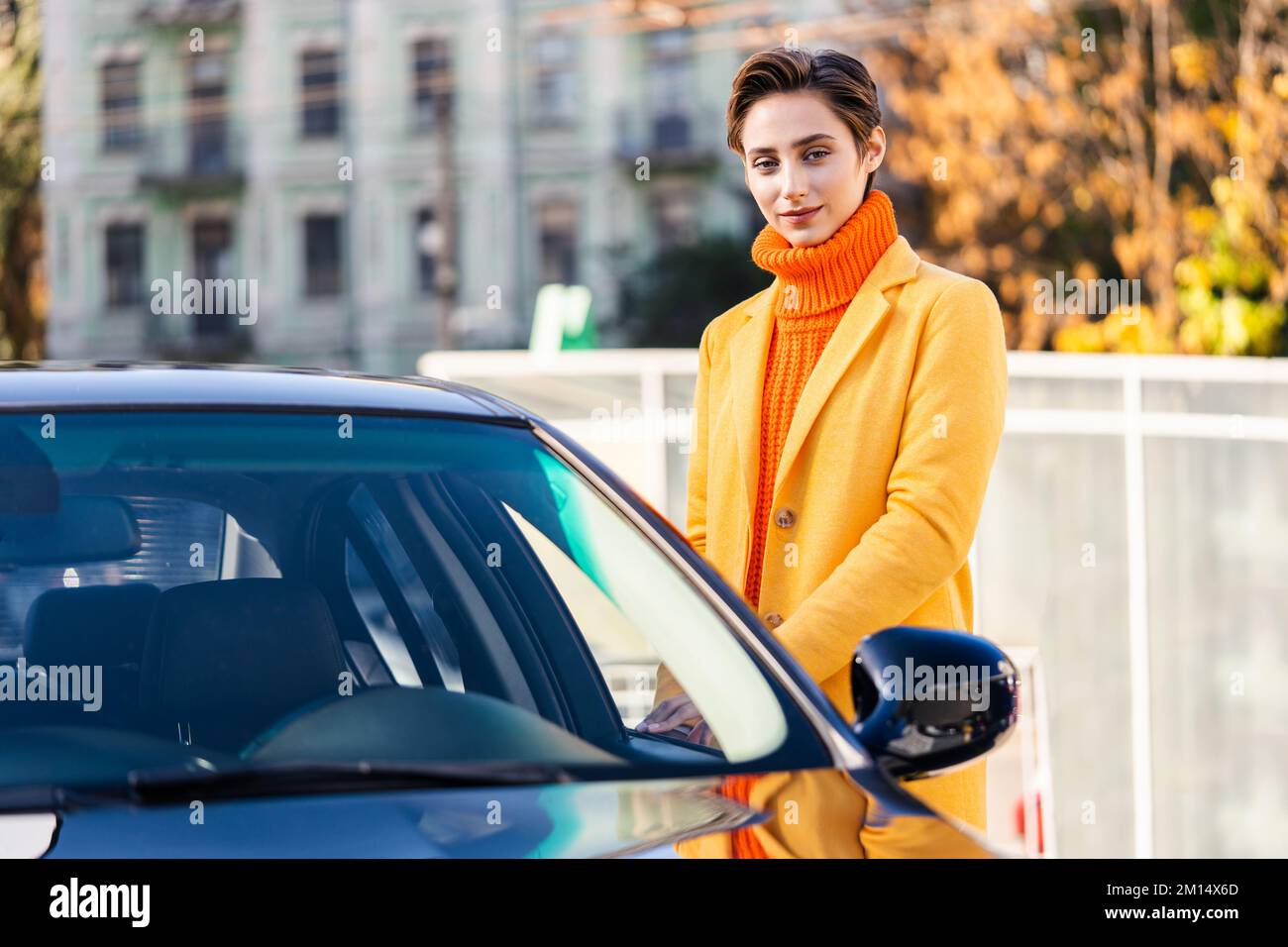 Beautiful young woman with short hair driving car in the city - Pretty ...