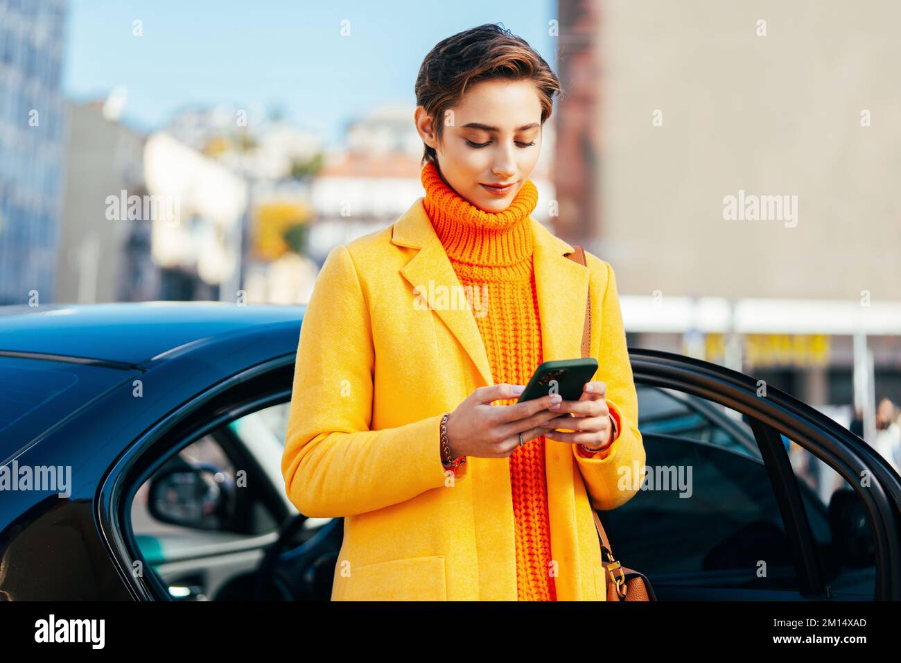 Beautiful young woman with short hair driving car in the city - Pretty ...