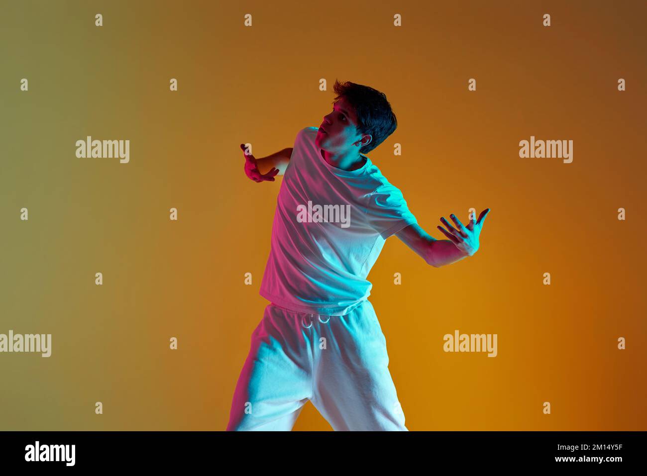 man dancing on yellow background. Neon lighting Stock Photo - Alamy