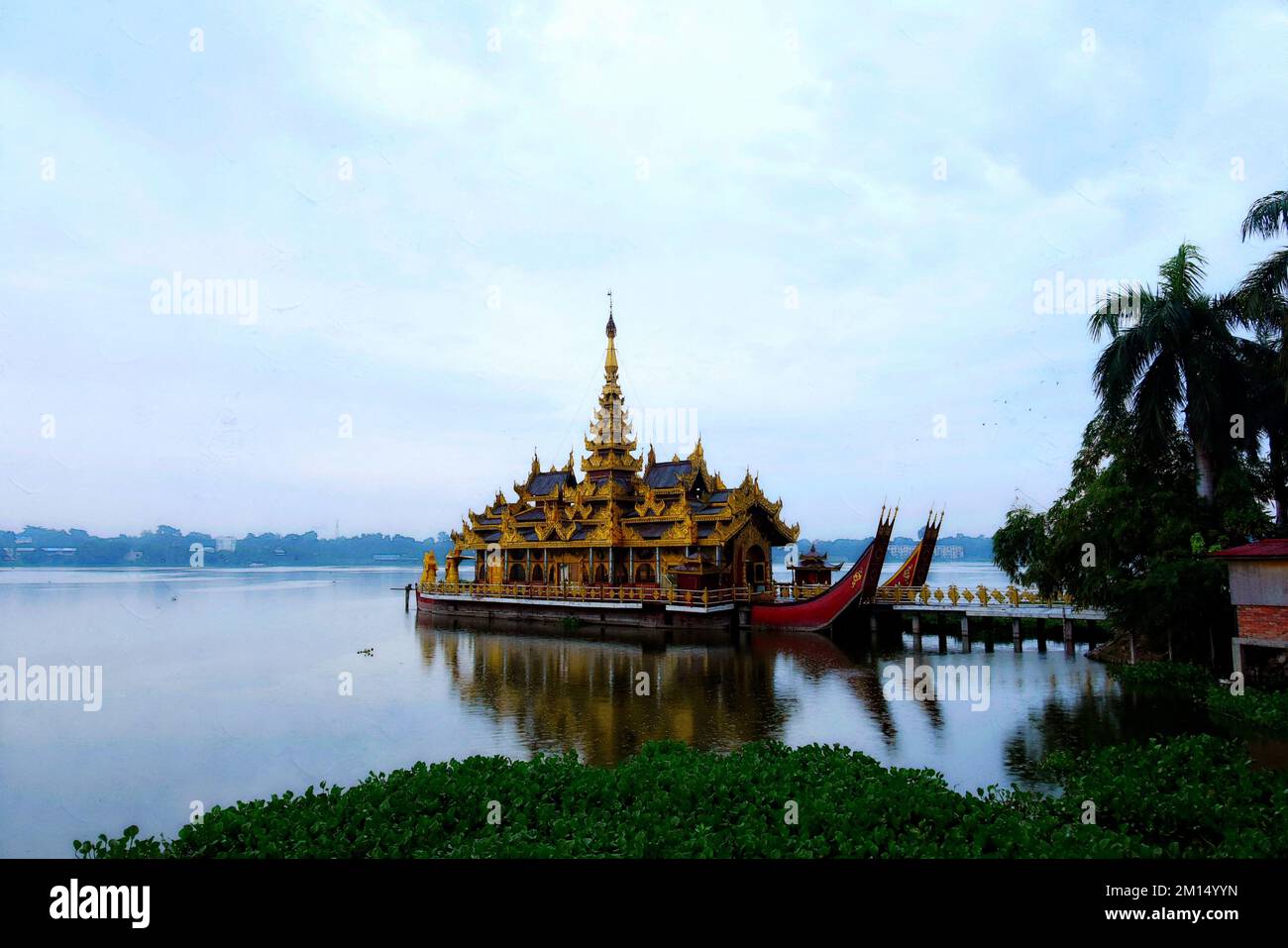 A traditional Asian architecture palace on a floating ship at the shore ...