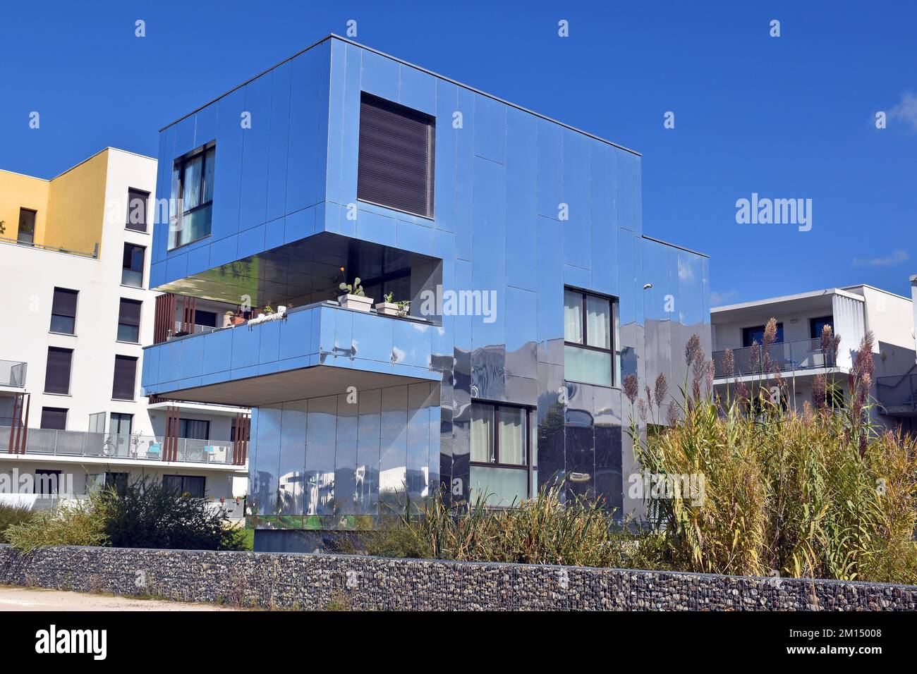 A three storey, house, or two aparments clad in highly reflective metal ...