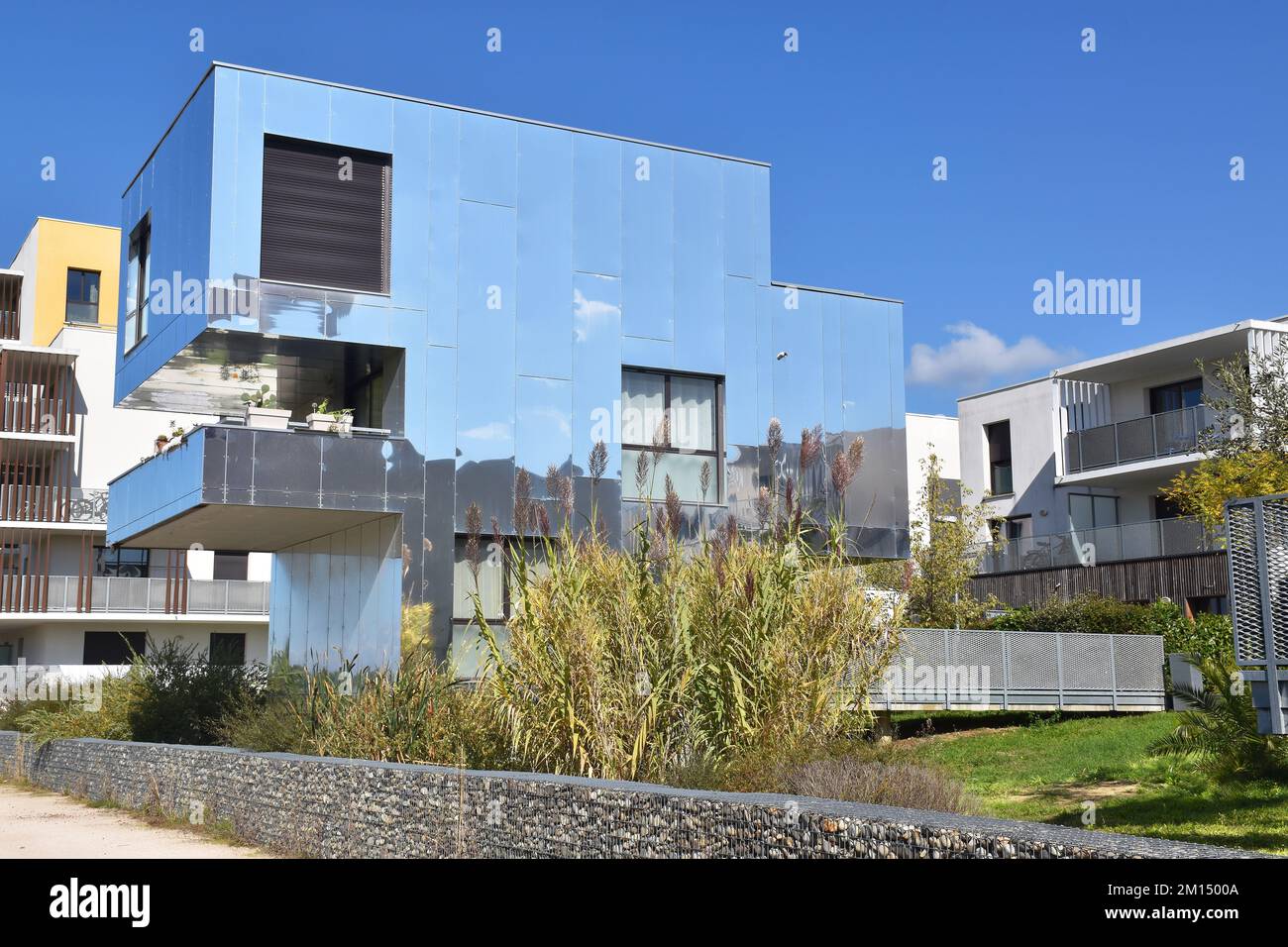 A three storey, house, or two aparments clad in highly reflective metal ...