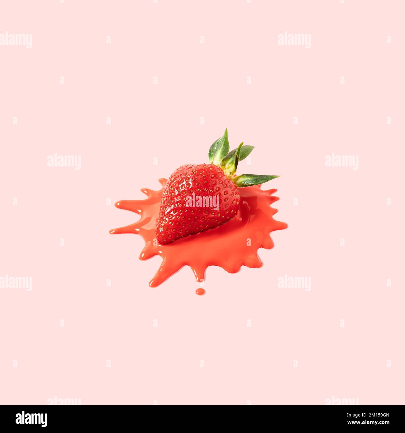 A fresh cut strawberry in a red melting cream on pink background Stock ...