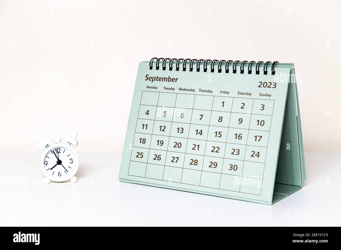 September 2023 calendar and small clock on white background isolated ...