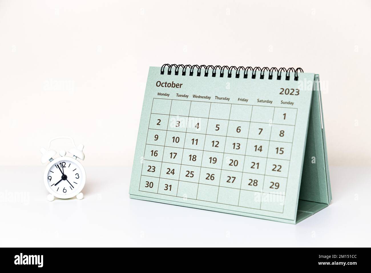 October 2023 calendar and small clock on white background isolated ...