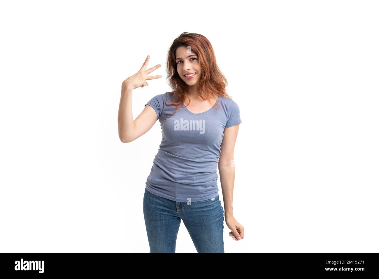 The portrait of a casually dressed woman showing number three with her ...
