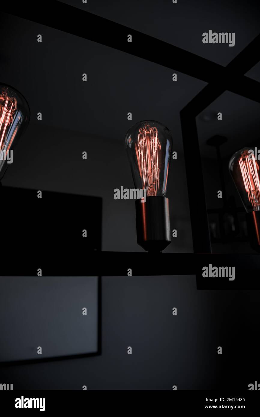 A vertical shot of modern lightbulbs on a contemporary chandelier with ...