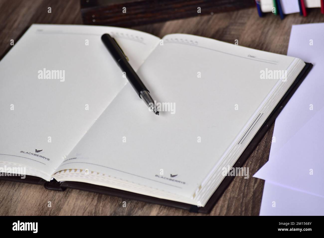 Blank notebook with pen on office table Stock Photo - Alamy