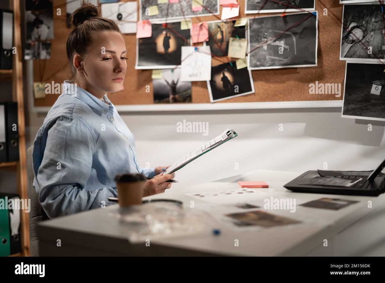 Smart detective attentively at evaluating clues while working in her ...