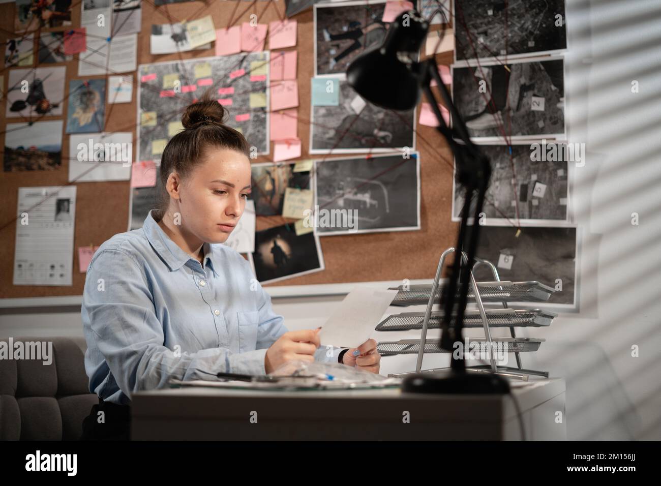 Female Detective working in her office, processing evidence. Copy space ...