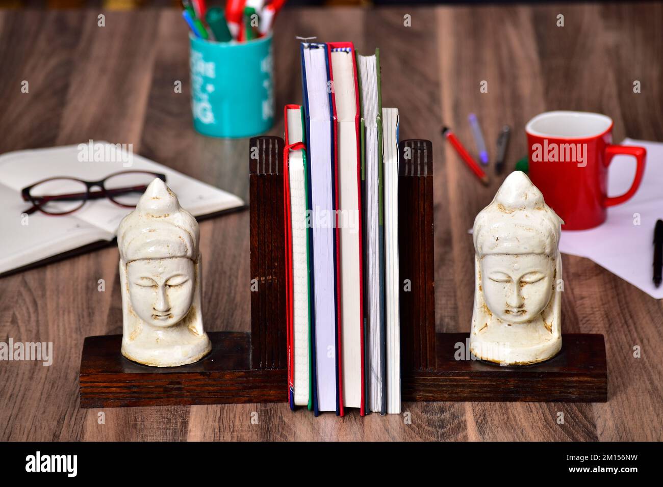 Handcrafted buddha bookend on table still life concept Stock Photo - Alamy