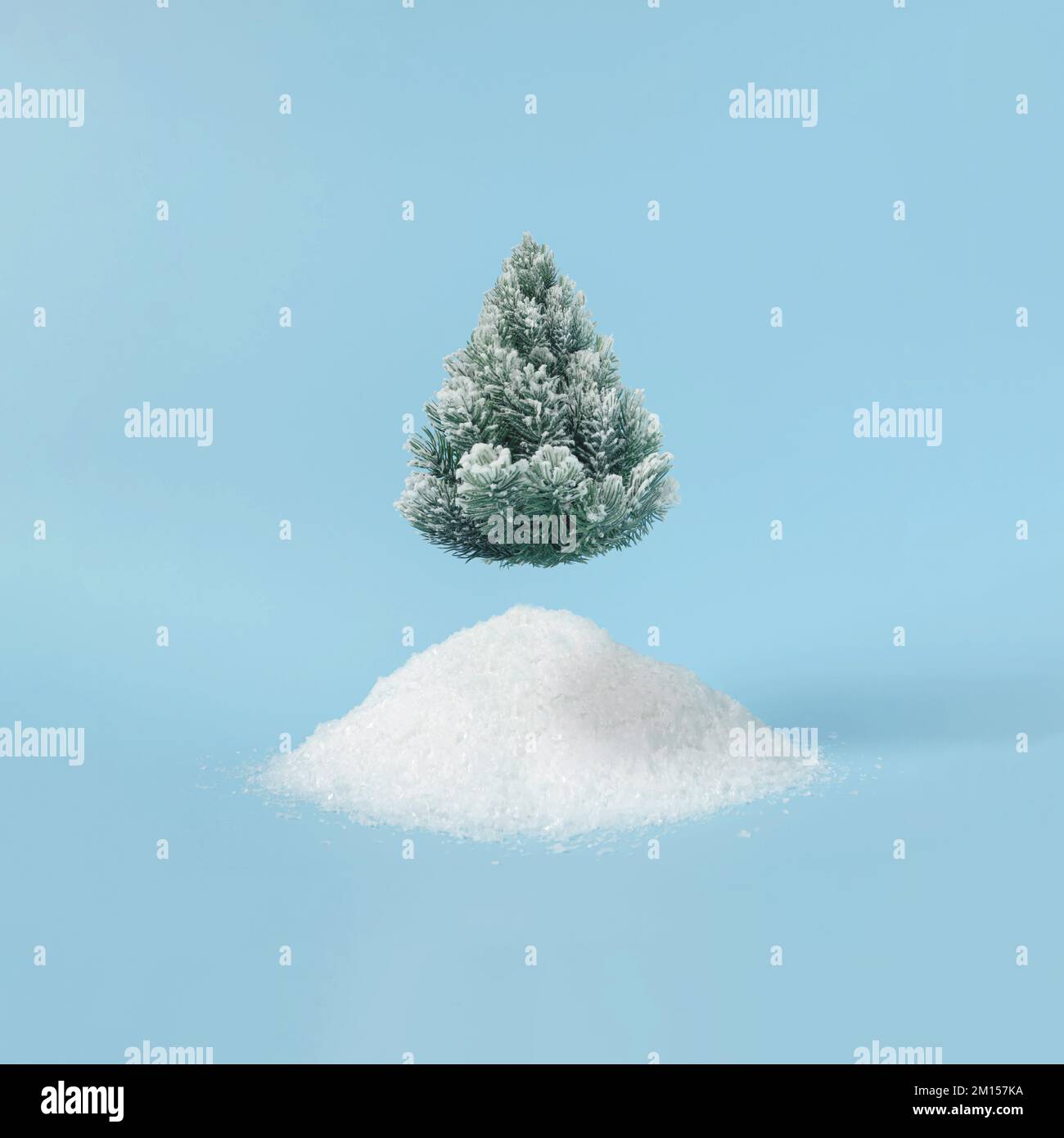A creative layout with snowy Christmas tree on bright blue background ...
