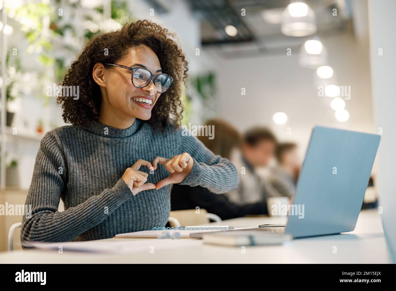 Smiling african woman speaks sign language with friends by video call ...