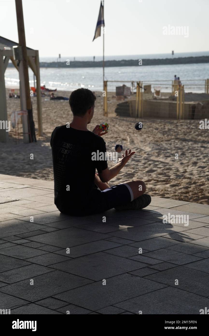 A guy is juggling as he solves a Rubiks cube Stock Photo - Alamy