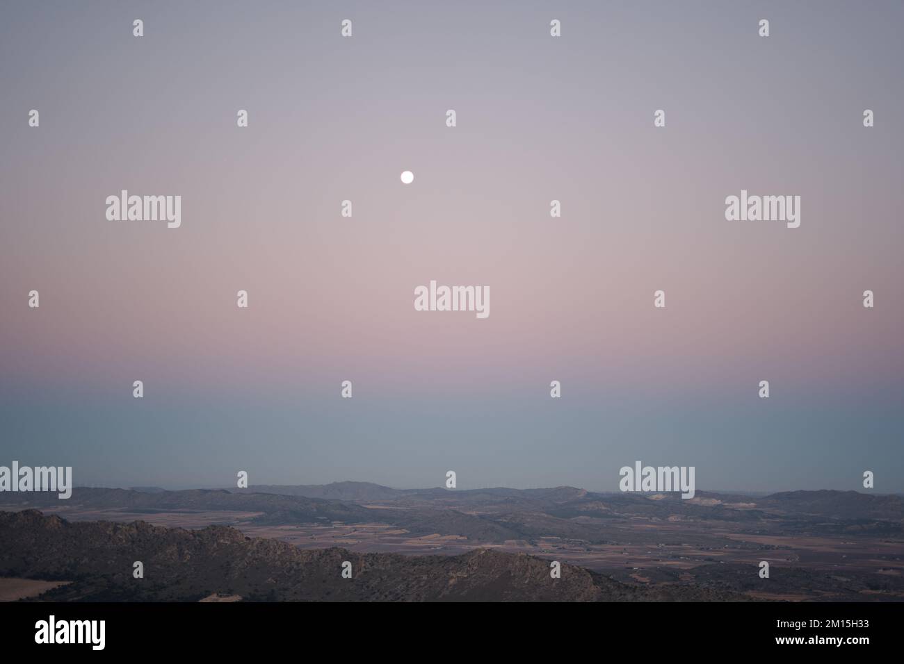 A beautiful white moon in a sunset sky over rural fields Stock Photo ...
