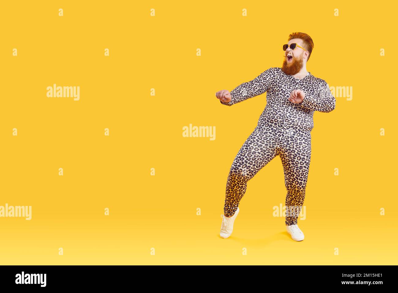 Funny Eccentric Fat Man In Pajamas With Leopard Print Dances On Orange