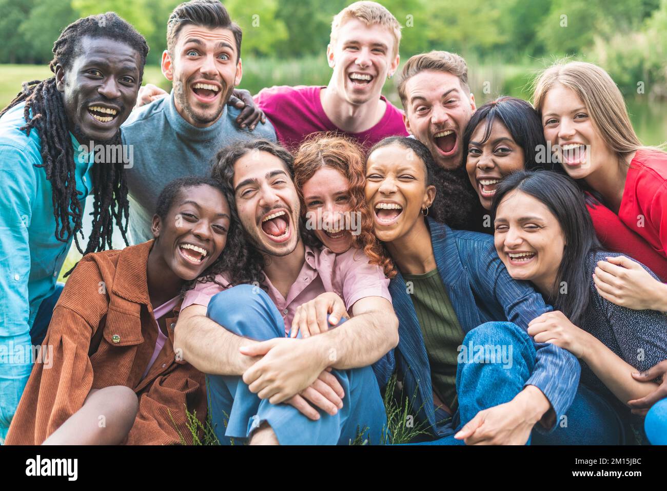Group of smiling people spending time together outdoor in the park ...