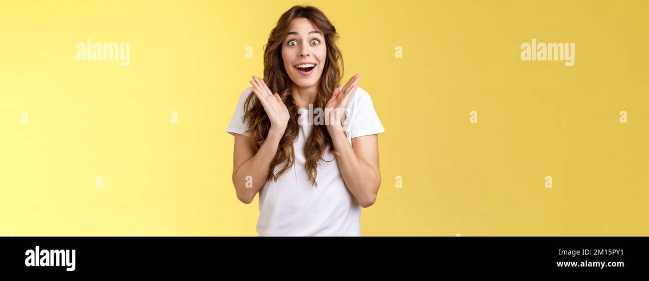 Surprised happy pleased impressed curly-haired girl gaze camera ...