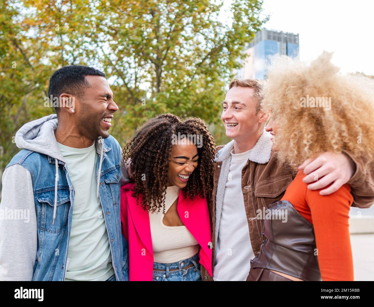Group of cheerful multiracial friends in street style outfits walking ...