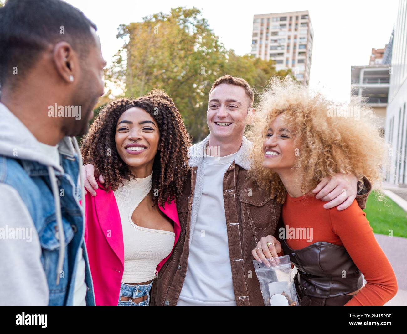 Group of cheerful multiracial friends in street style outfits walking ...