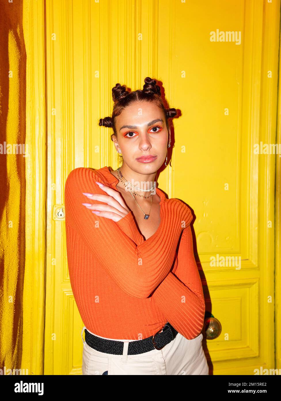 Portrait of serious young woman with bantu knots and orange eyeshadow ...