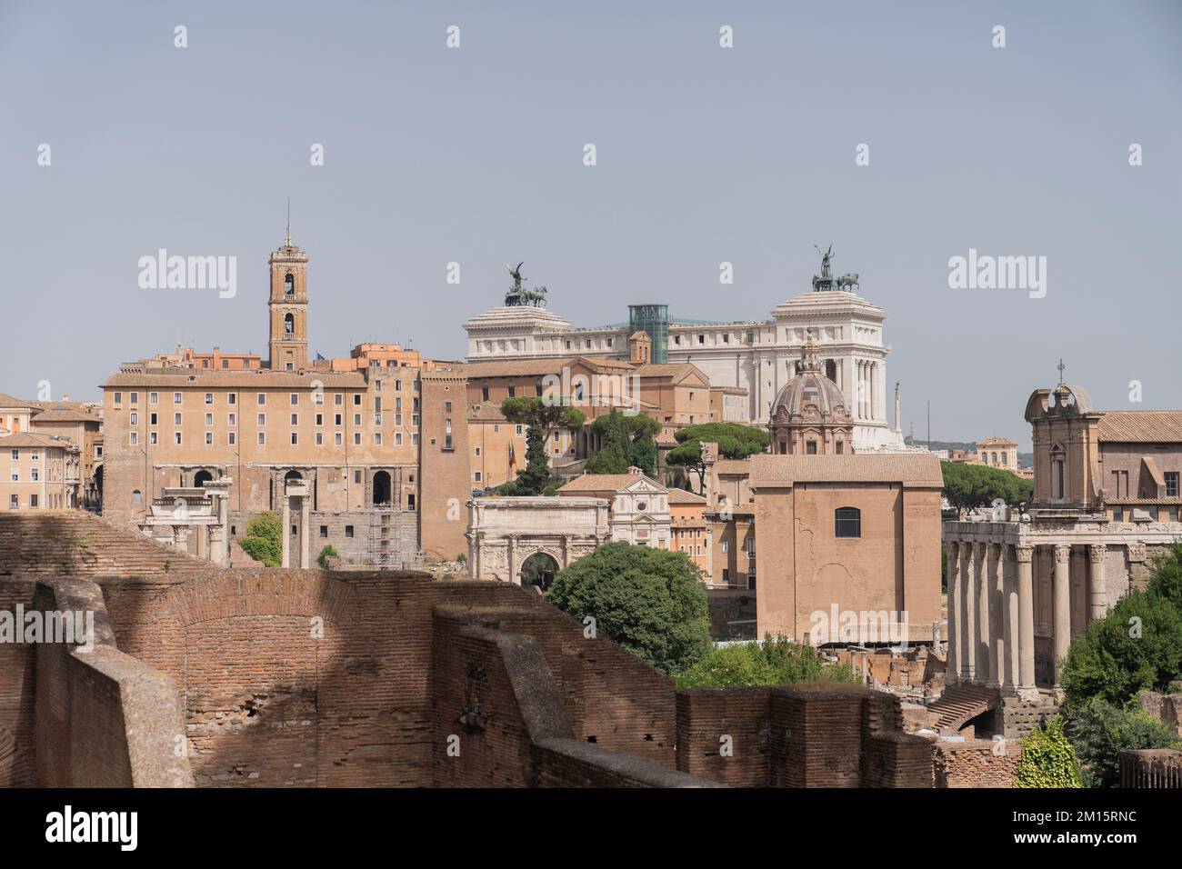 Old buildings located behind stone wall near Roman Forum against gray ...