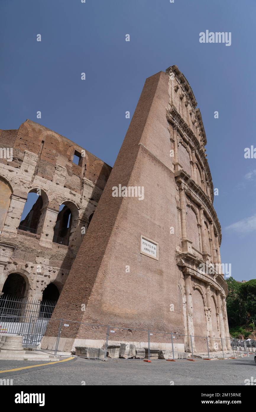 Low angle of historic Colosseum building located against blue sky on ...