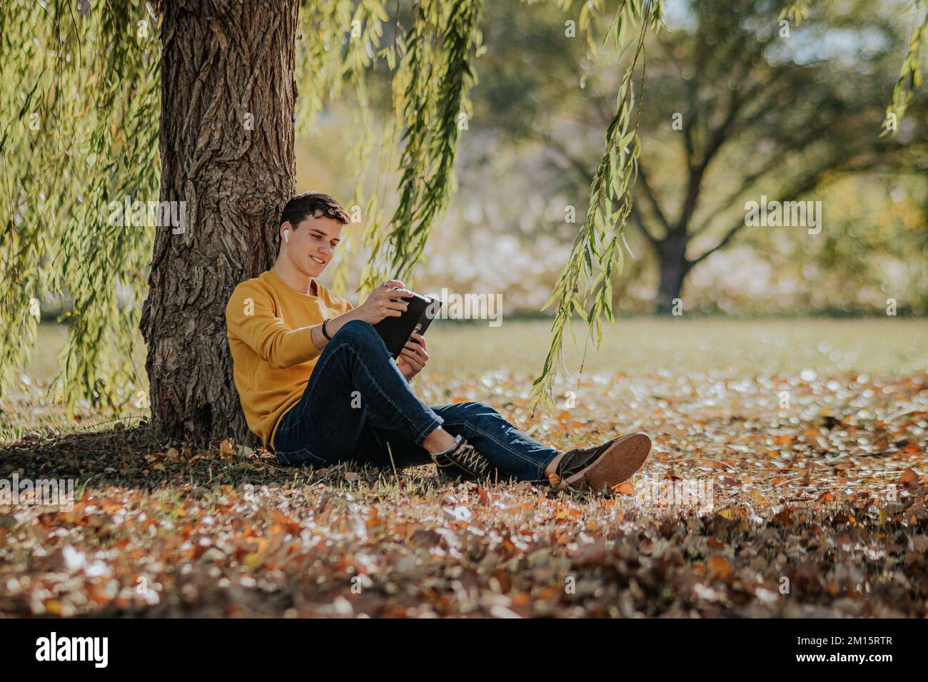 Man reading book under tree hi-res stock photography and images - Alamy