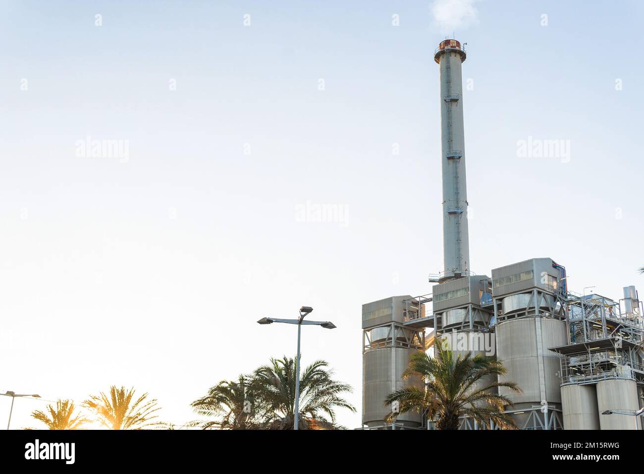 Low angle of contemporary building of industrial factory with high pipe ...