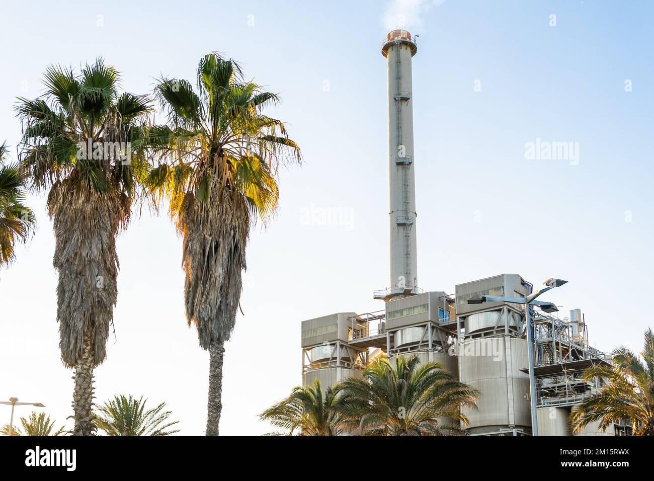 Low angle of contemporary building of industrial factory with high pipe ...