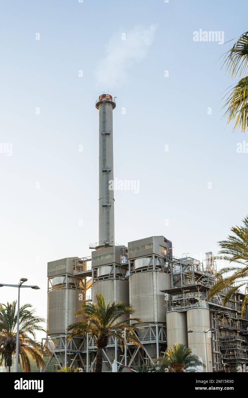 Low angle of contemporary building of industrial factory with high pipe ...