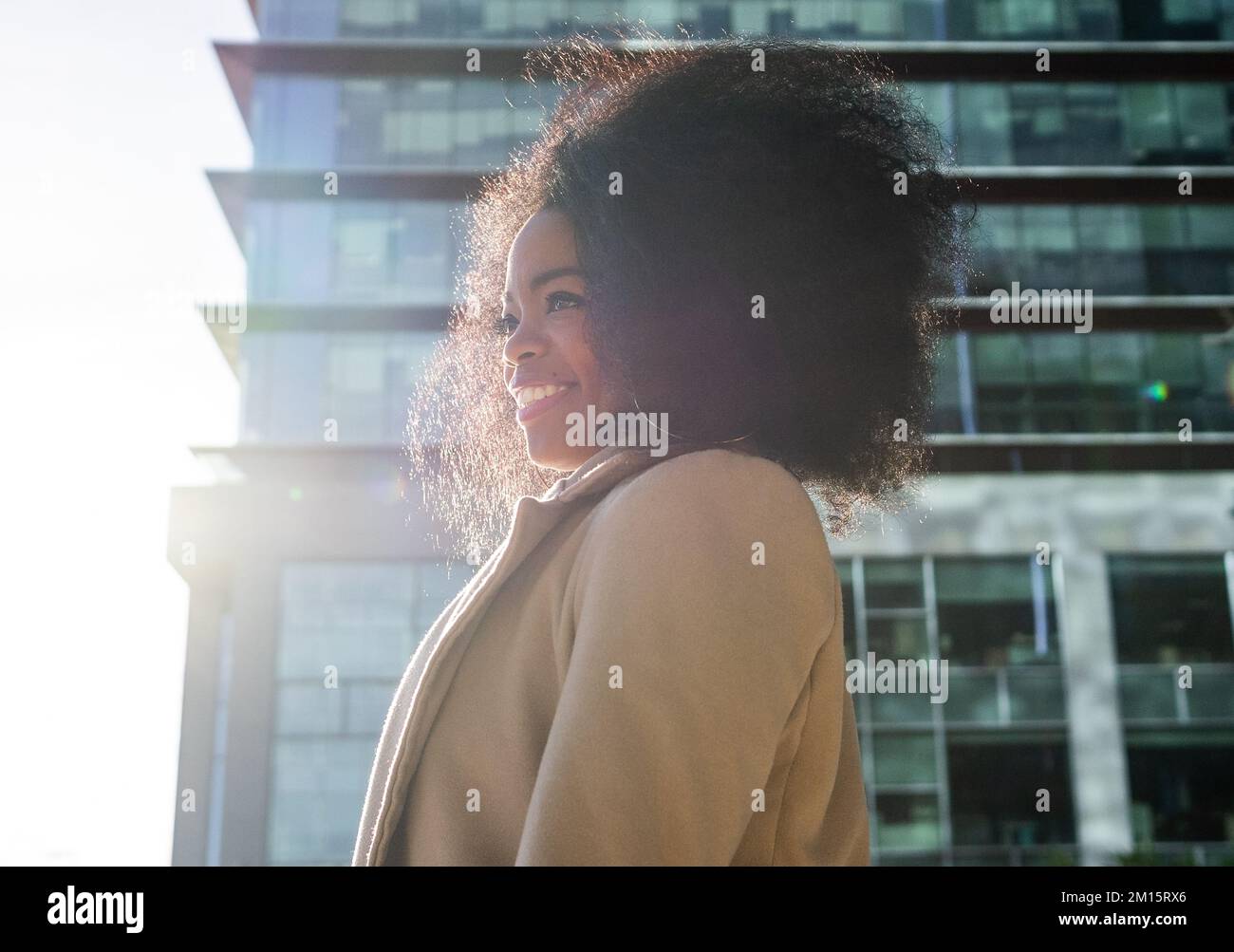 Low angle side view of confident young African American female with fro ...