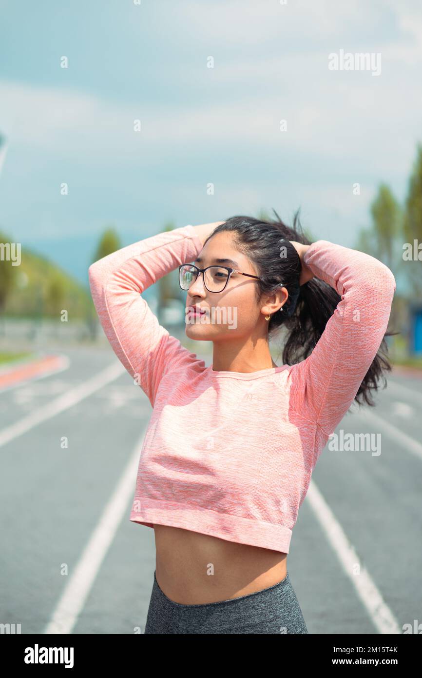 Sportive female in activewear and glasses standing looking away on ...