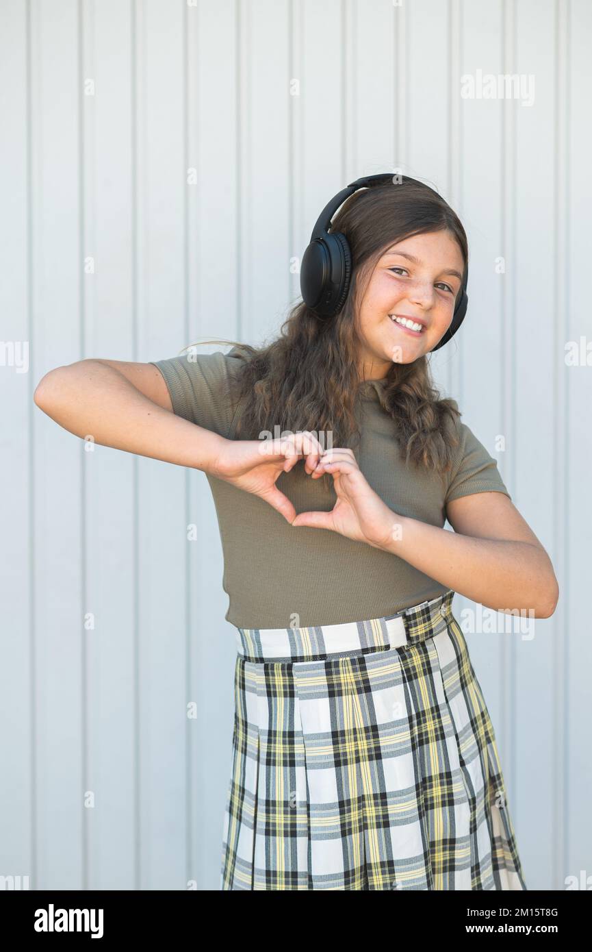 Content girl in casual outfit doing heart shape with hands and looking ...
