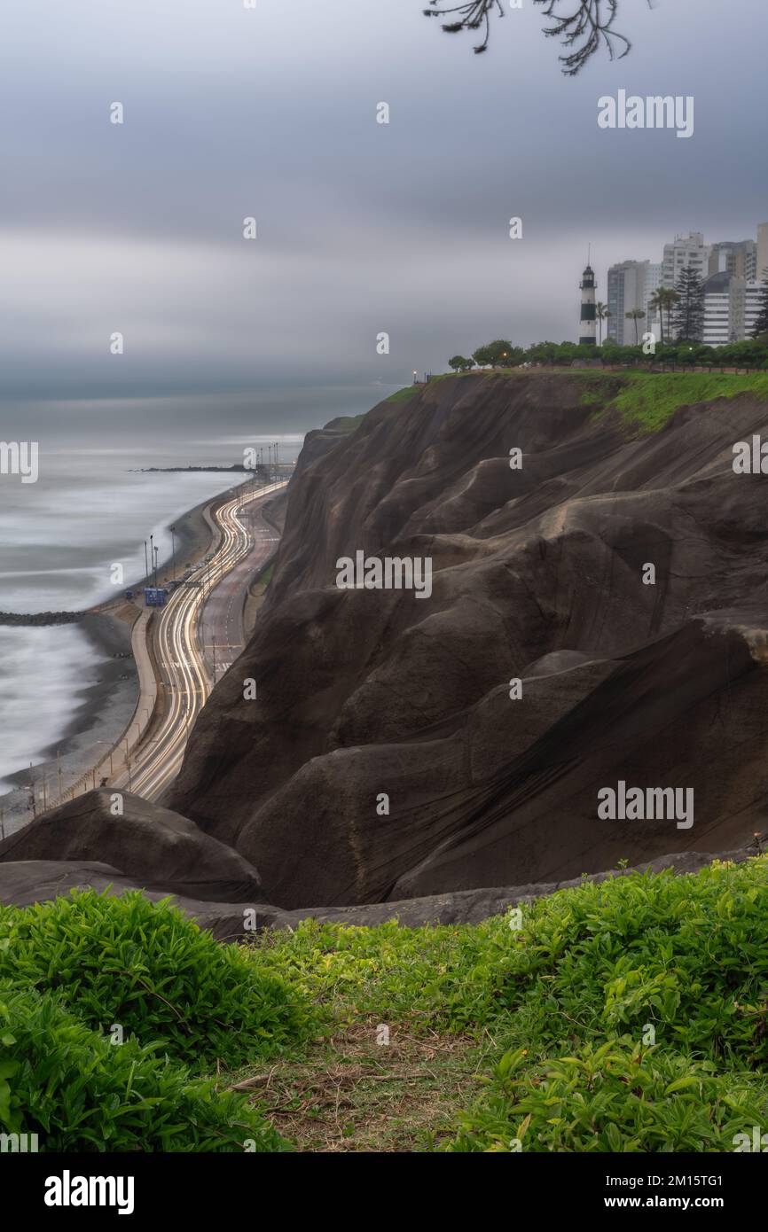 Shot of Miraflores boardwalk and curvy road with trails of light ...