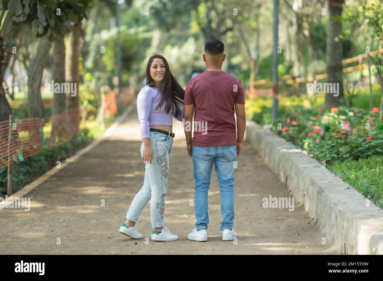 Full body back view of unrecognizable boyfriend standing near smiling ...