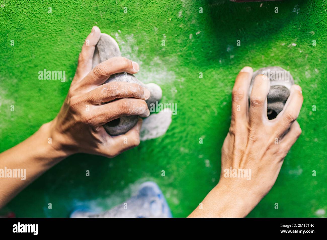 Unrecognizable athlete grasping on plastic grip covered with chalk ...