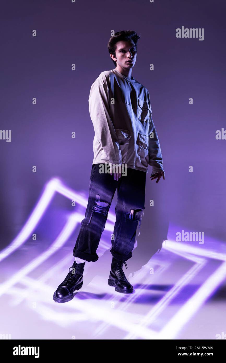 Full body of young male model in straitjacket on purple background ...