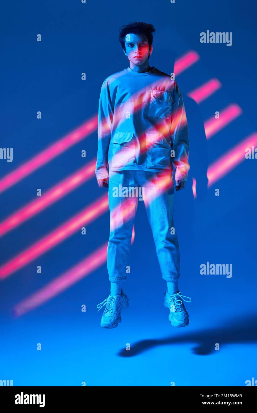 Full body of young male model in straitjacket on blue background ...