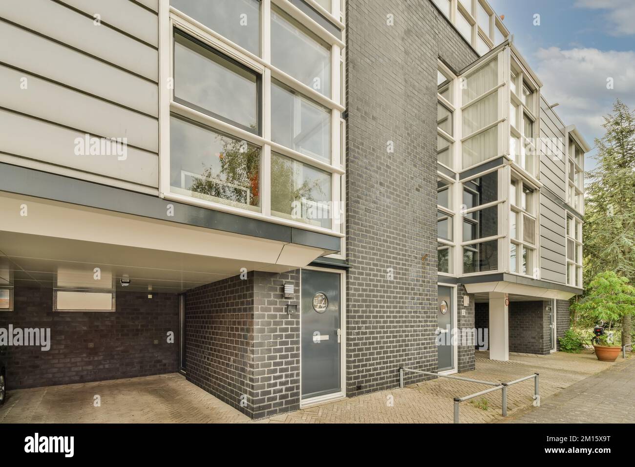 View of a street with houses lined up under a blue sky with clouds ...