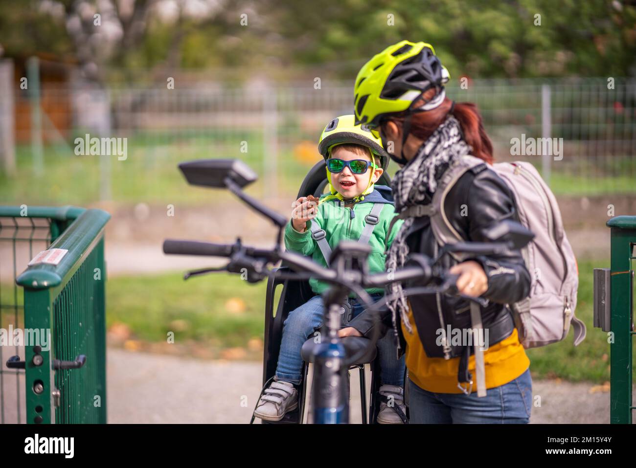 Young female cyclist in protective helmet and backpack riding bike with ...