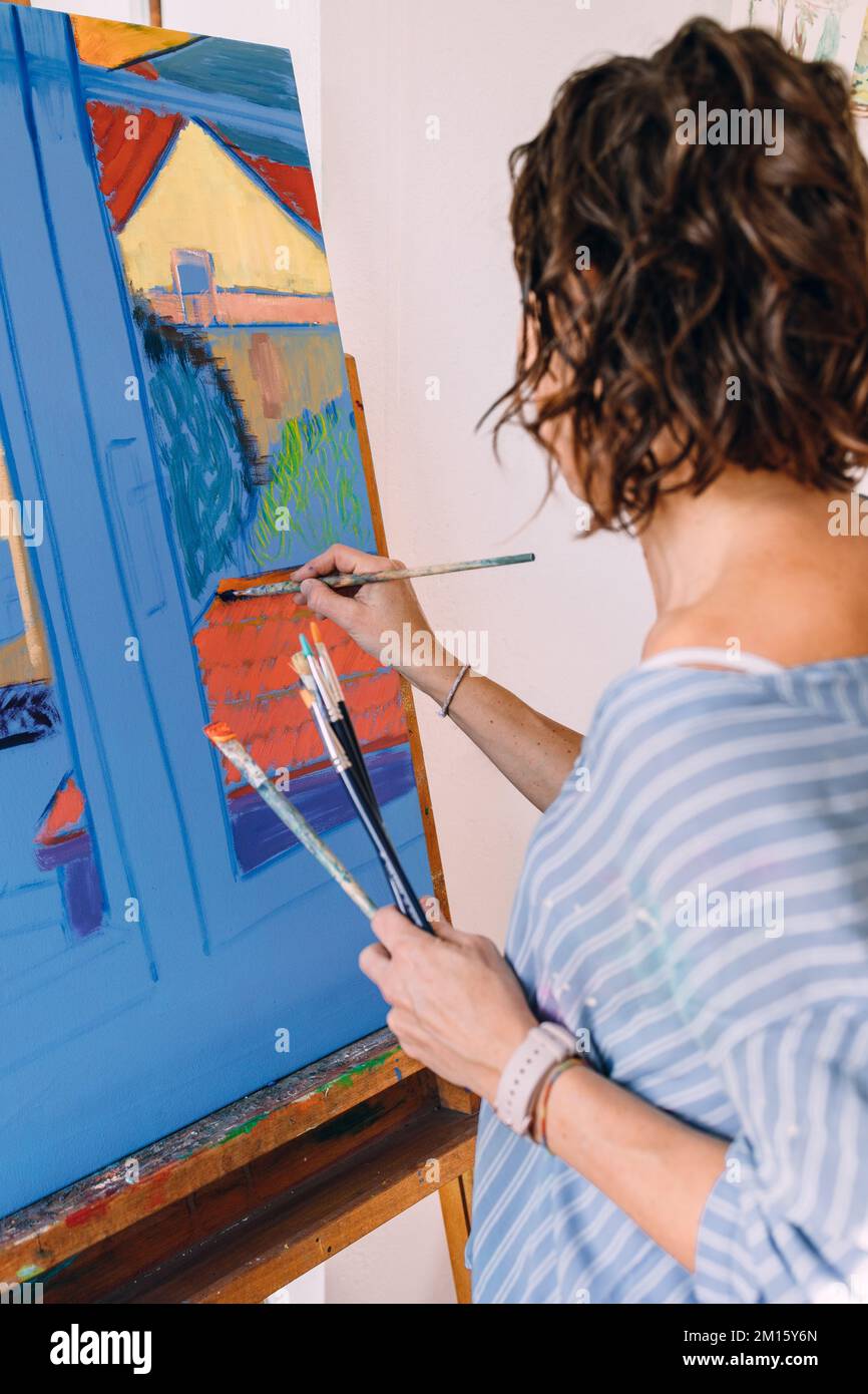 Side view of anonymous young female in striped shirt standing near ...